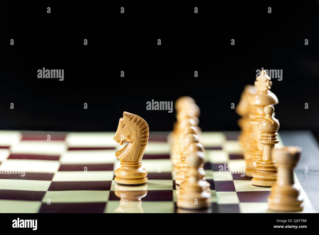 Brown chess pieces on the chessboard with black background Stock Photo ...