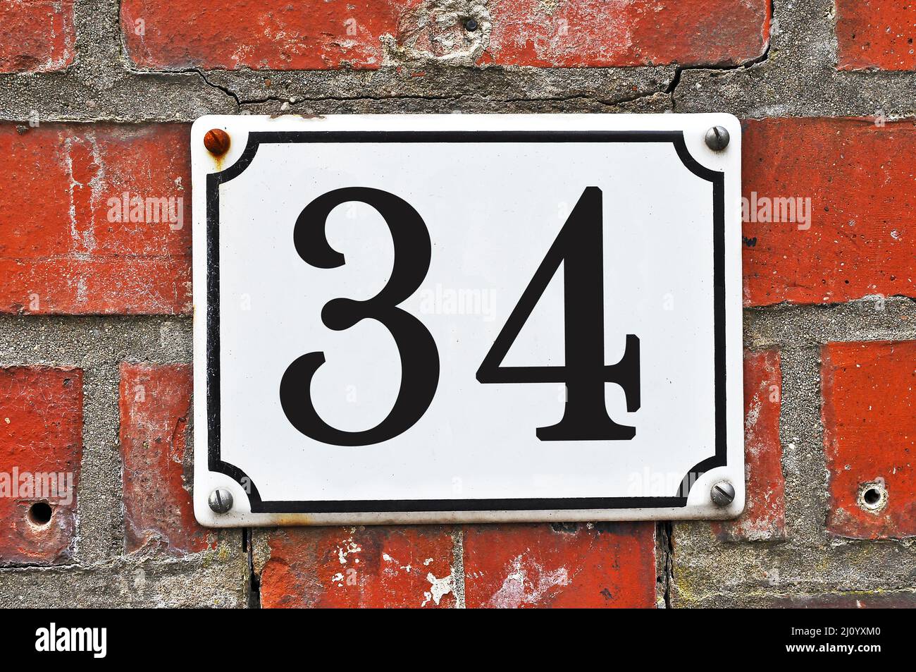 Sign of a street number 34 on a red brick wall Stock Photo - Alamy