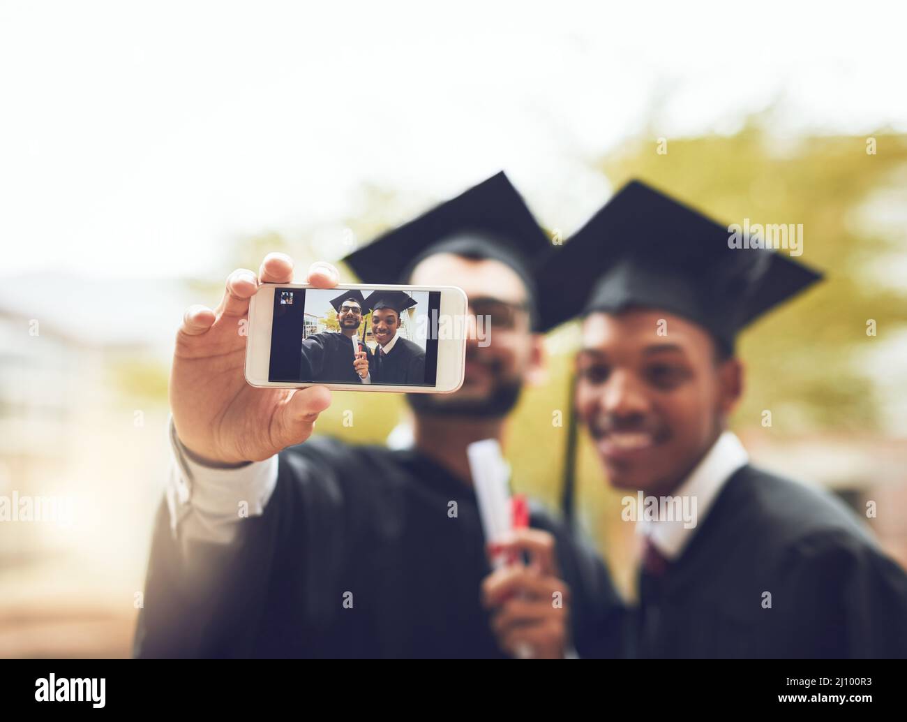 Celebrate graduation day with a selfie. Cropped shot of two students ...