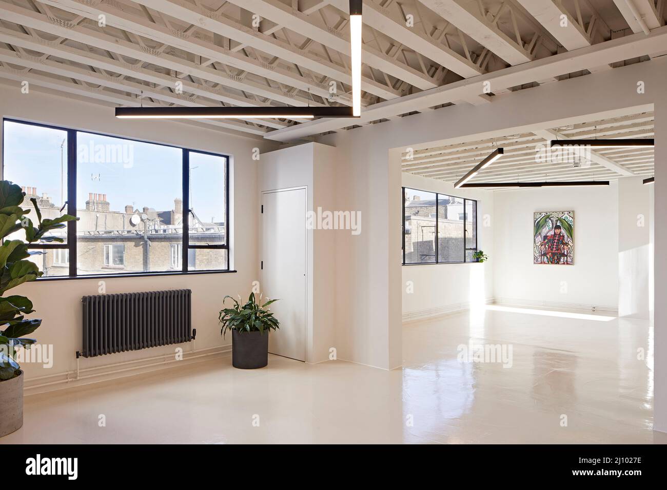 View through unfurnished office spaces with exposed ceiling. Symes Mews ...