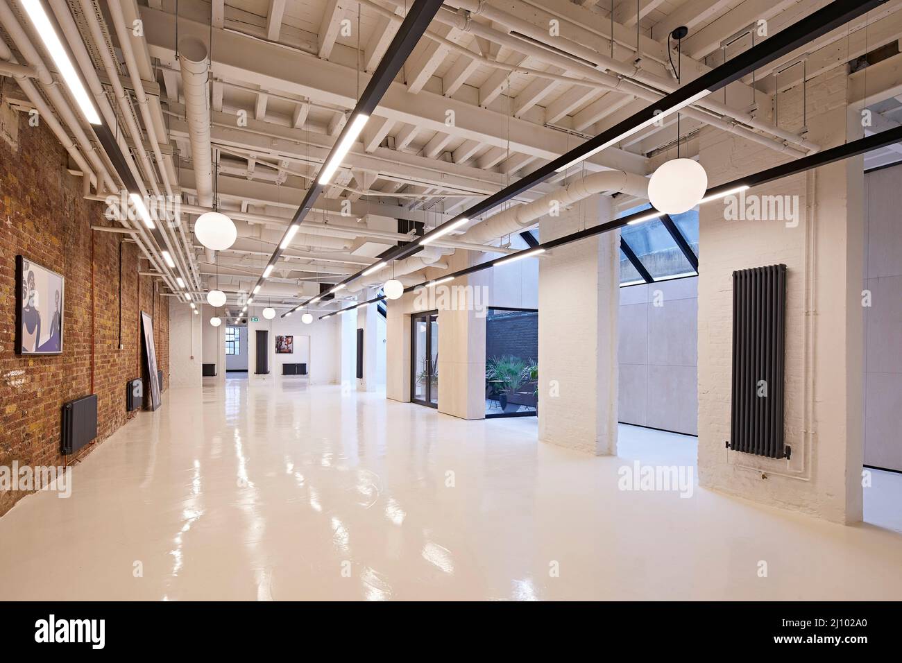 Office space with original brick wall and skylights. Symes Mews, London ...
