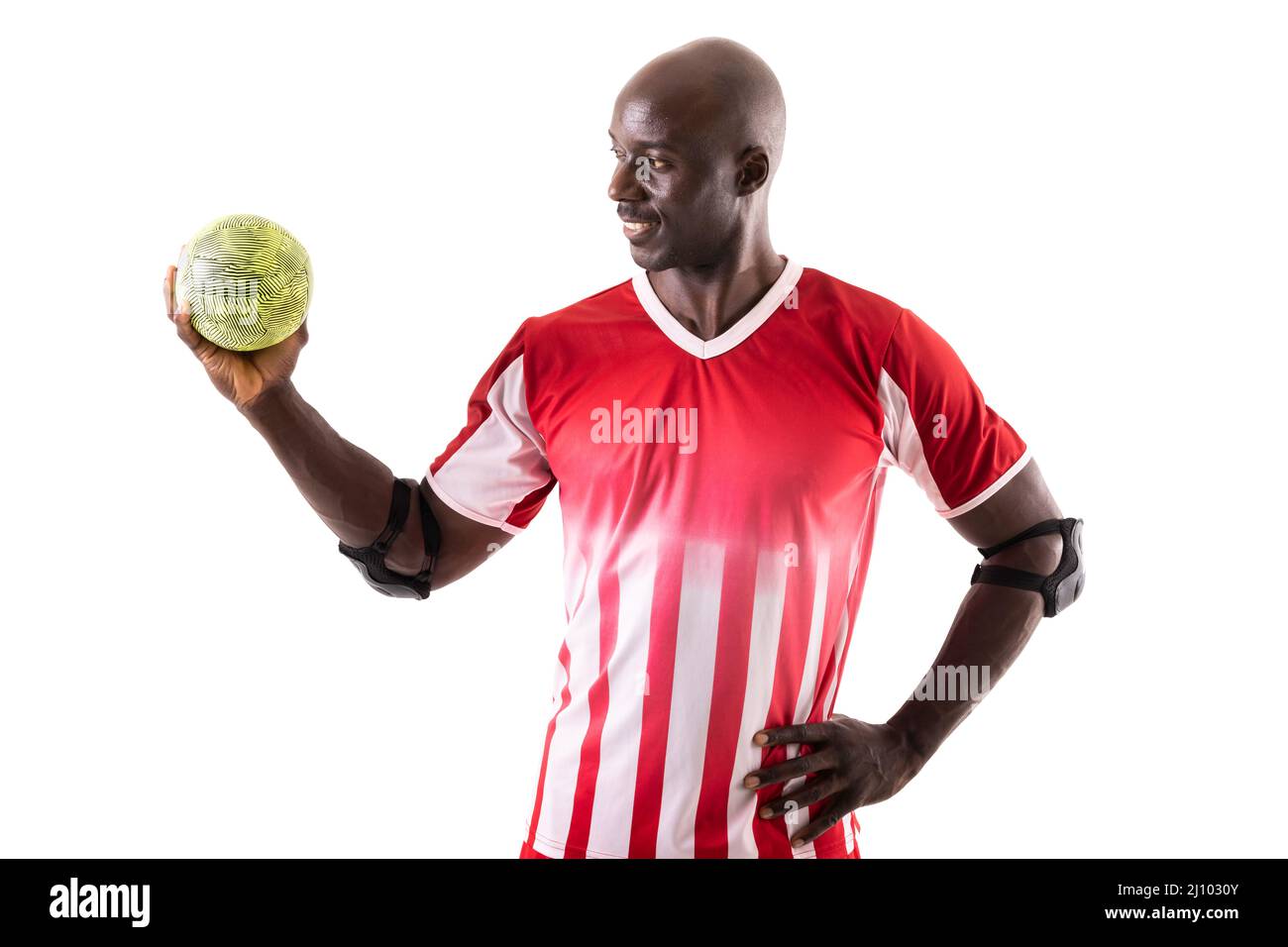 Smiling african american young male handball athlete looking at ball ...