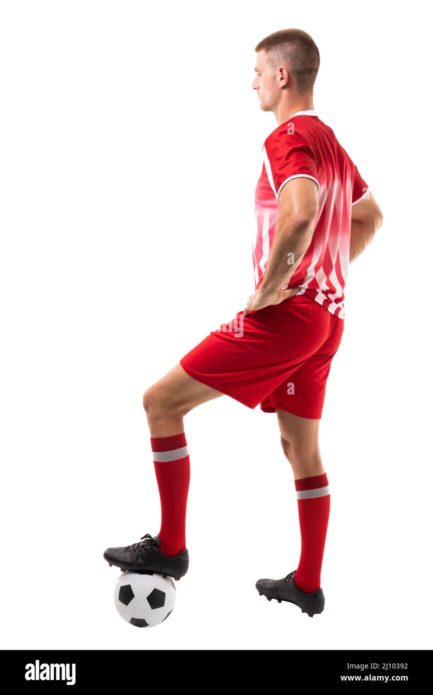 Full length side view of young male caucaisan soccer player stepping on ...
