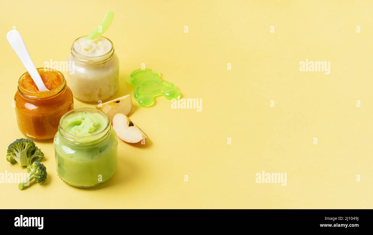 Baby food frame jars yellow background Stock Photo - Alamy