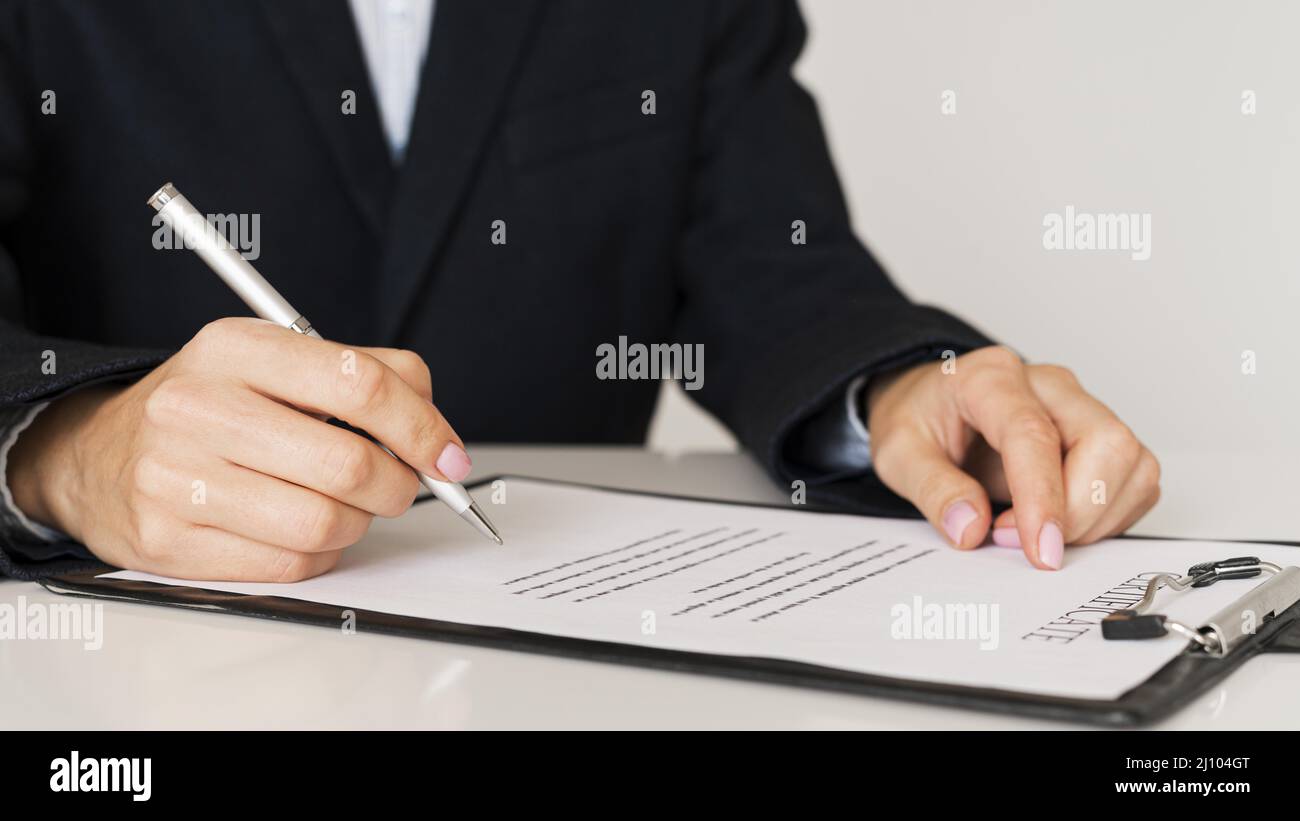 Person signing certificate front view Stock Photo - Alamy