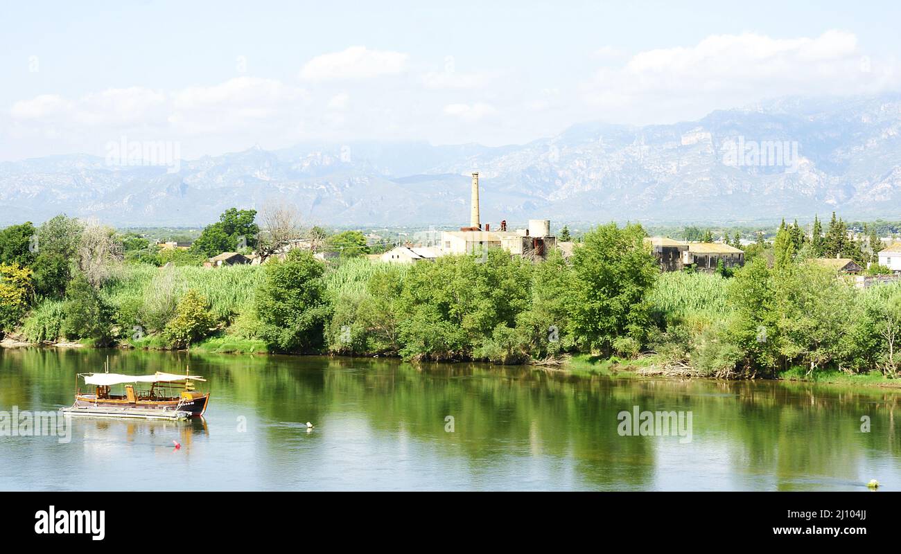 Tour boat navigating the Ebro river as it passes through Tortosa ...