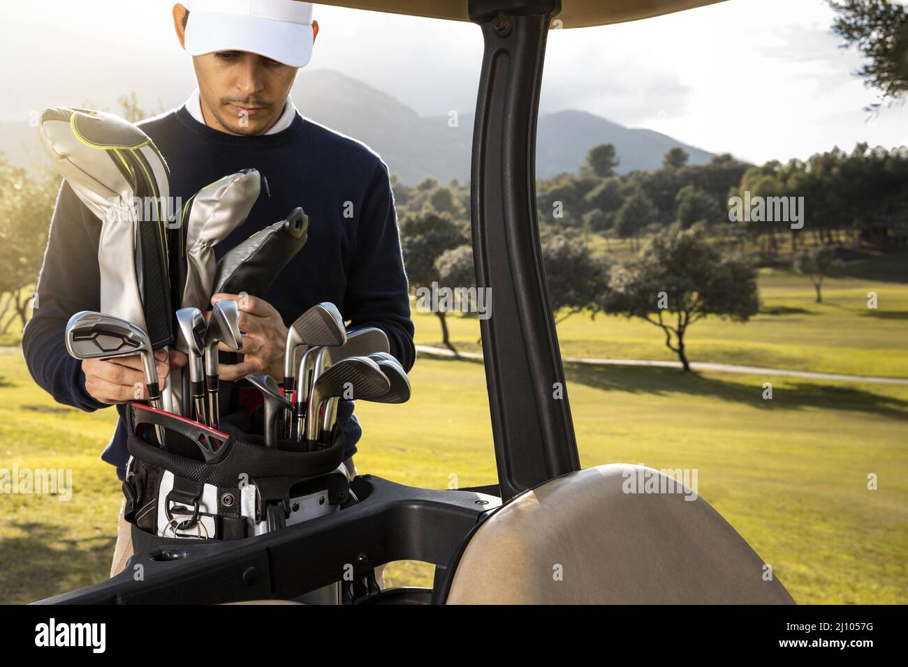 Front view man putting clubs golf cart Stock Photo - Alamy