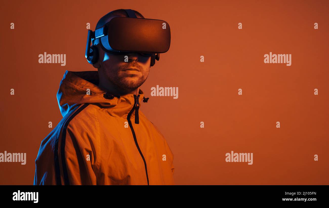 Man wearing virtual reality gadget with orange light Stock Photo - Alamy