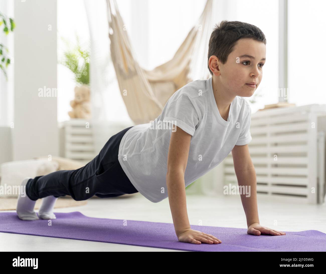 Full shot kid doing plank Stock Photo - Alamy