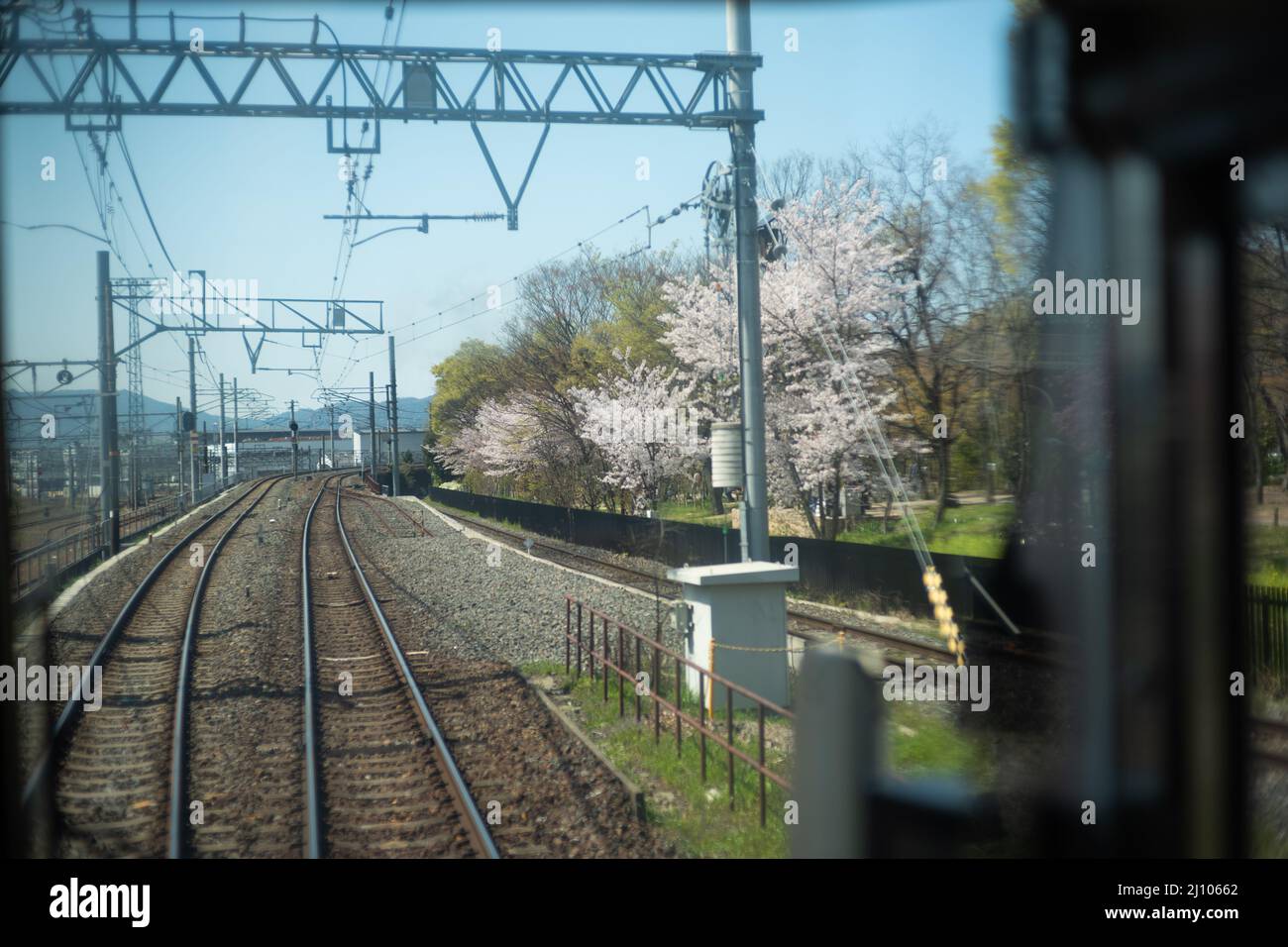 Train rails near the trees on a sunny spring day with sky in background ...