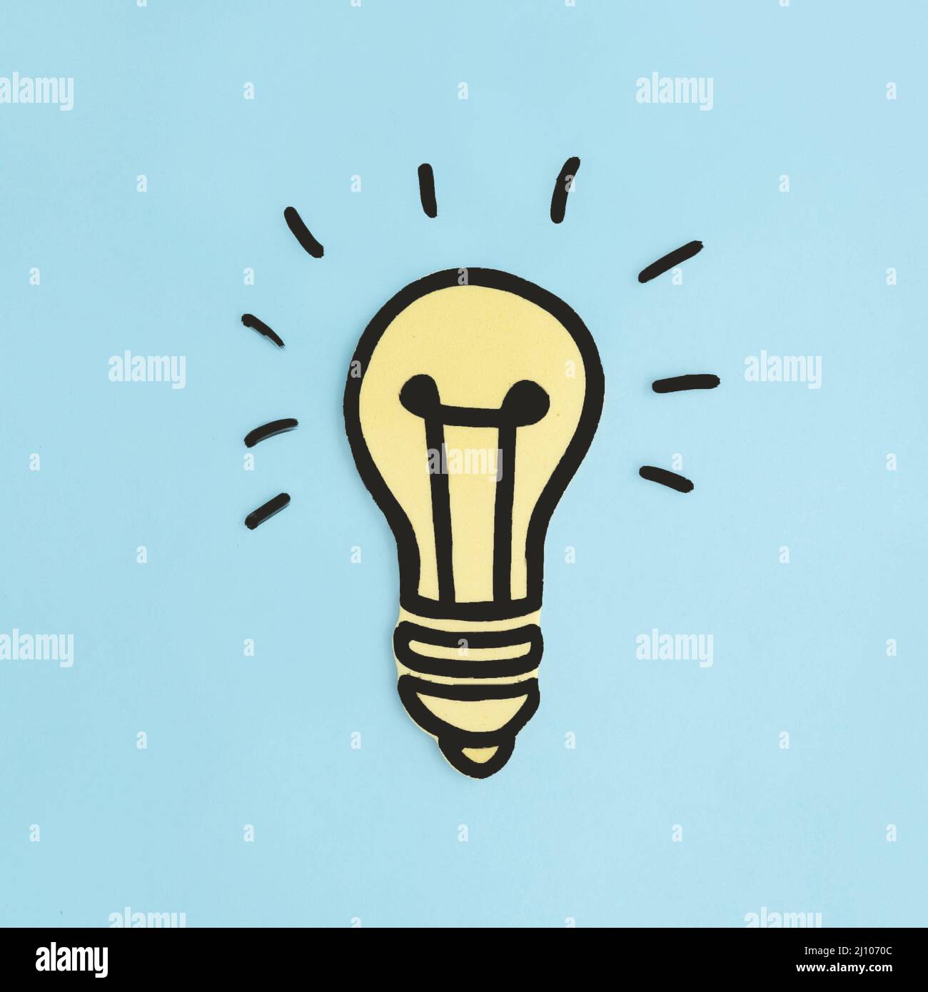 Illuminated paper cutout yellow light bulb blue background Stock Photo ...