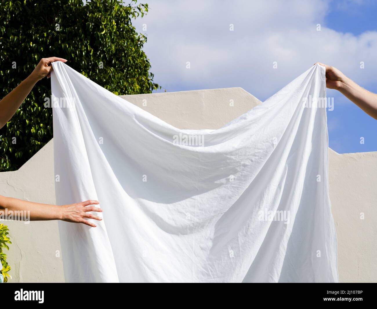 Close up two people hanging white sheet line Stock Photo - Alamy