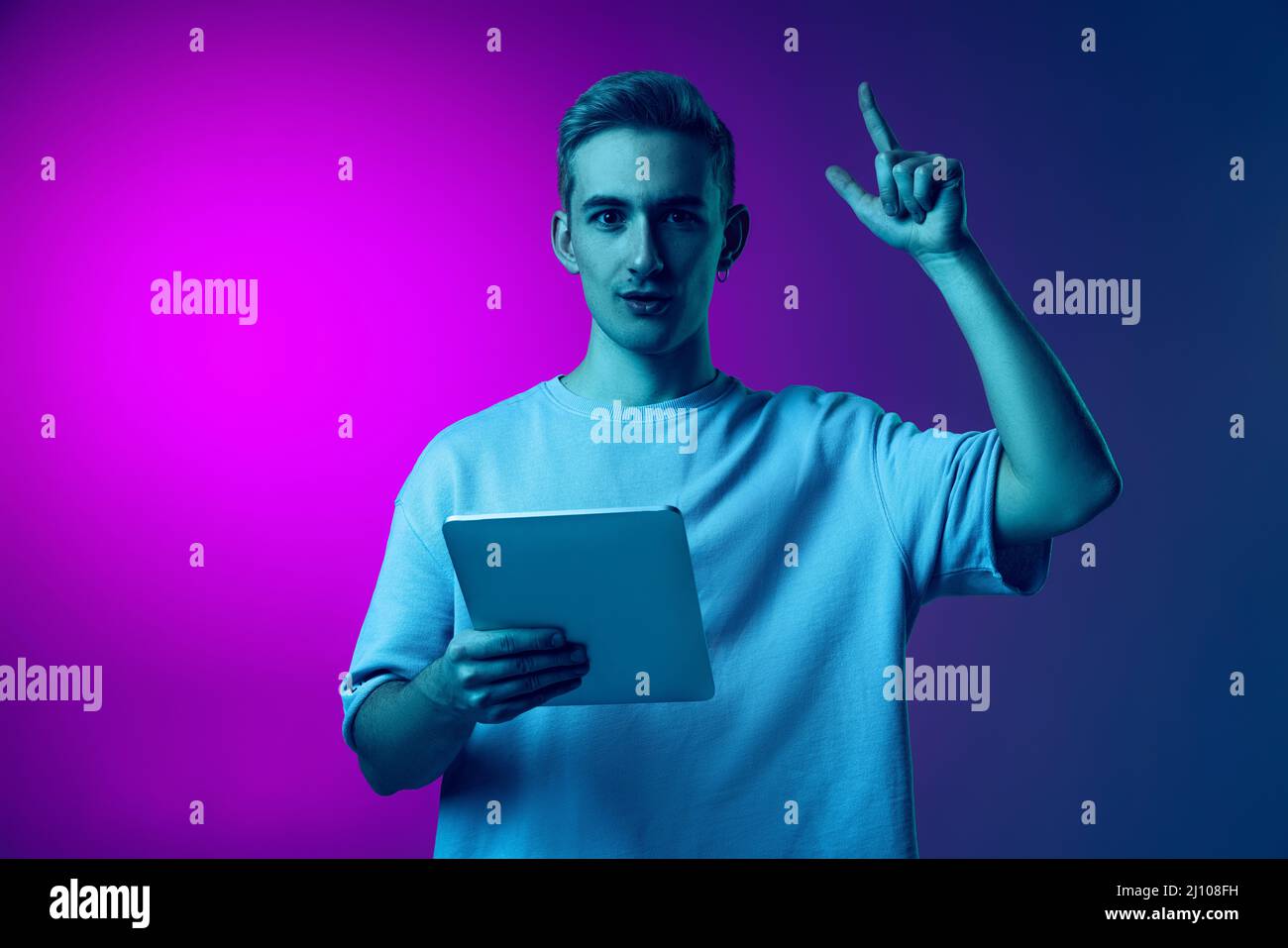 Portrait of young man with tablet rising finger up symbolizing new ...