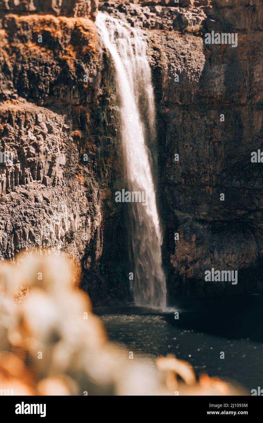 Vertical shot of waterfall dropping in a river from rocky mountain ...