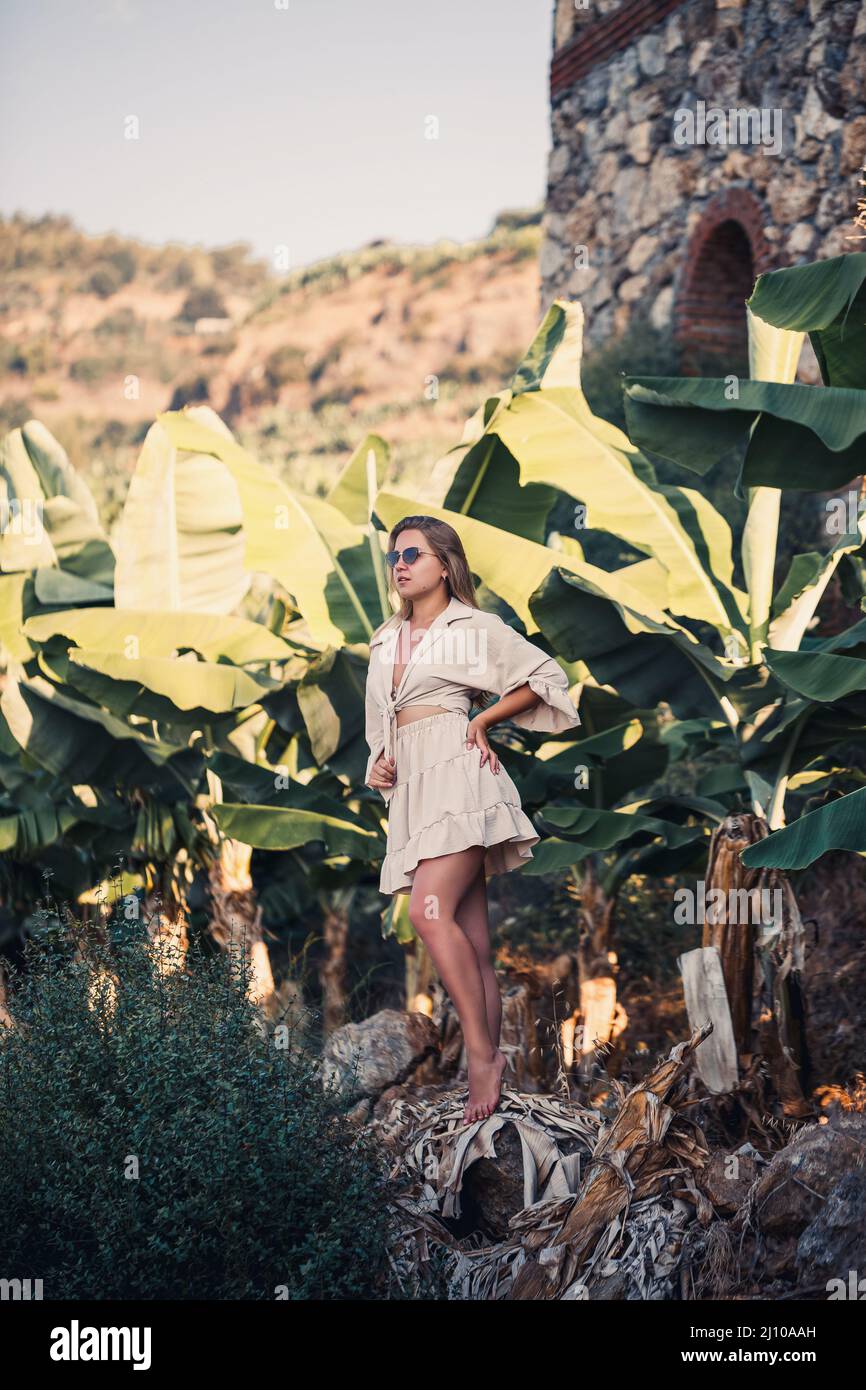 Exotic tropical woman near green leaves of banana bush. Tropical island ...