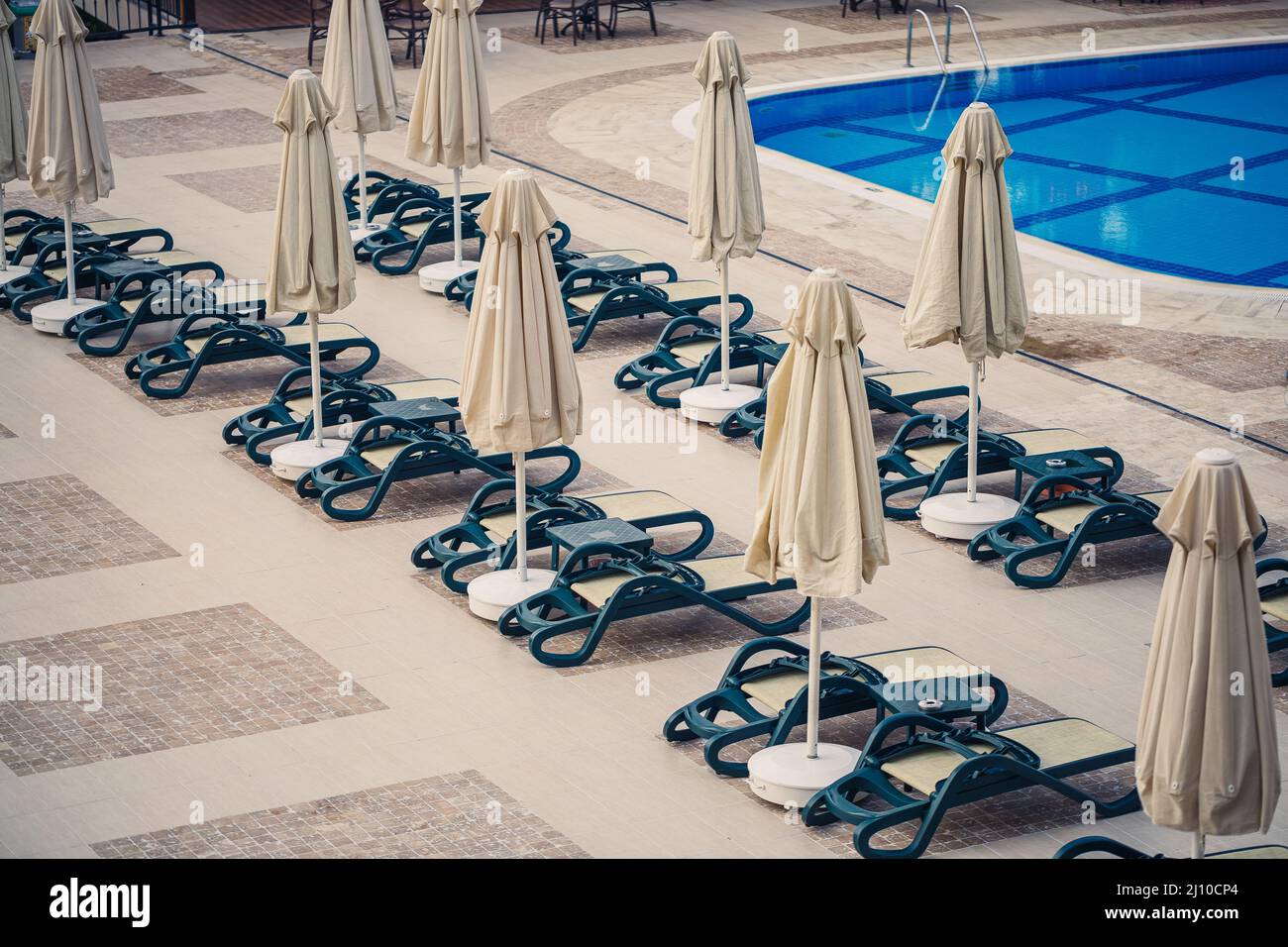 Plastic sun loungers and parasols for sun protection are placed on the ...