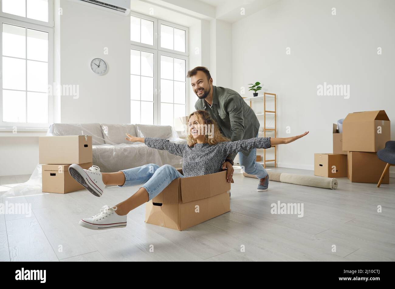 Happy young family having fun in the living room of their new home on ...