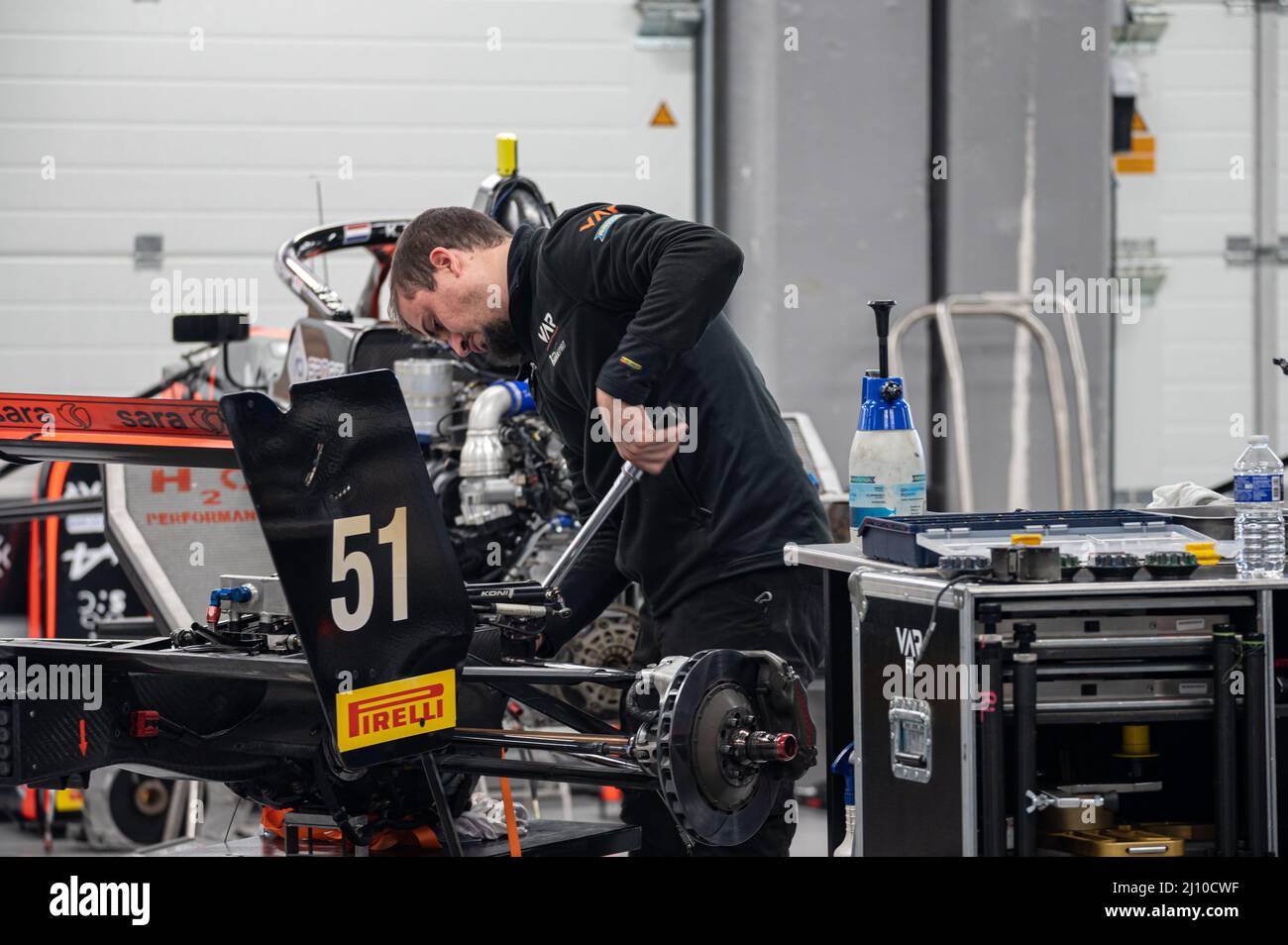 Closeup of the mechanic repairing and improving the racing car in the ...