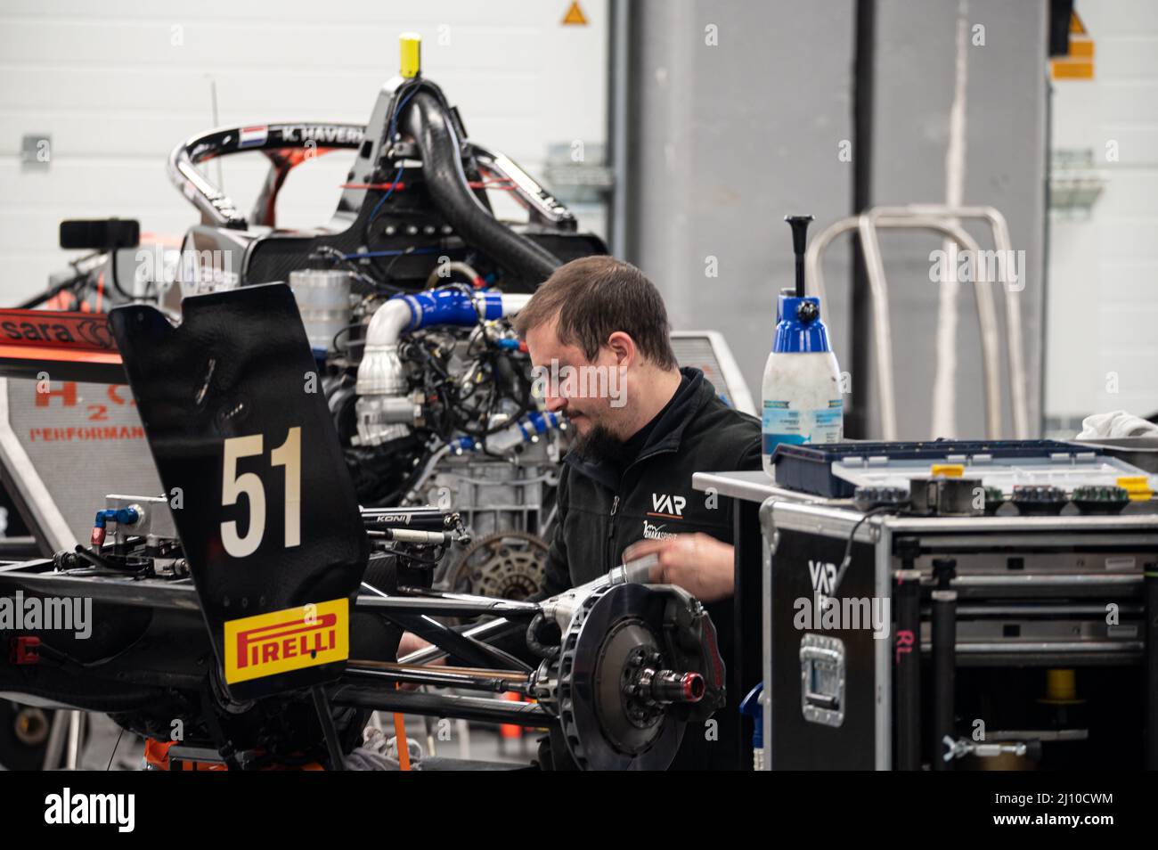 Closeup of the mechanic repairing and improving the racing car in the ...