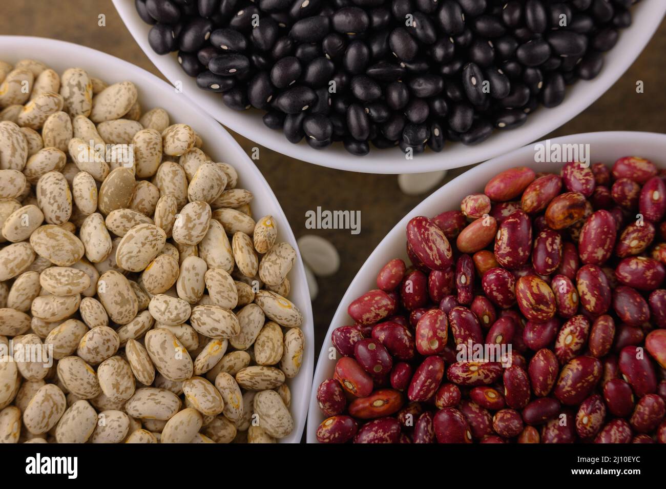 The photo shows red, white, black beans. The texture of the seeds is ...