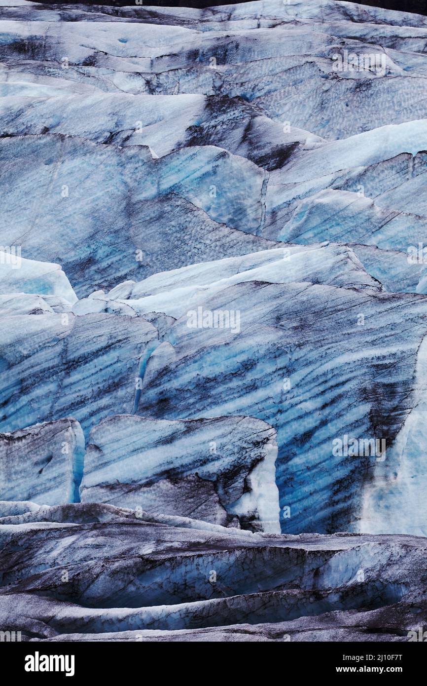 A massive ice wall on Svinafellsjokull Glacier, flowing down from the ...