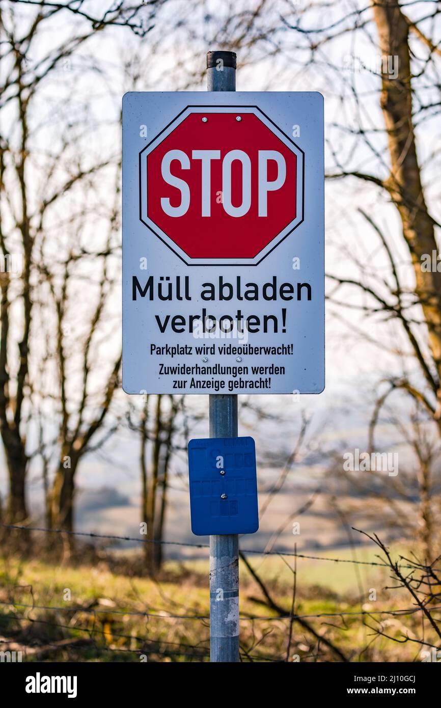 Stop sign against garbage thrown into nature that creates environmental ...