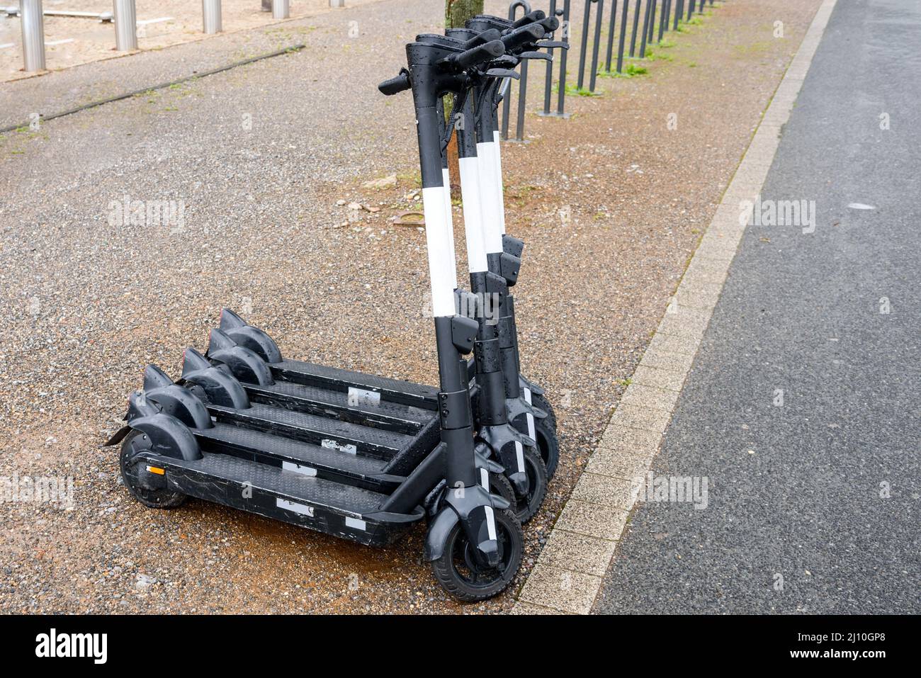 Sharing electric scooters along a path in public park Stock Photo - Alamy