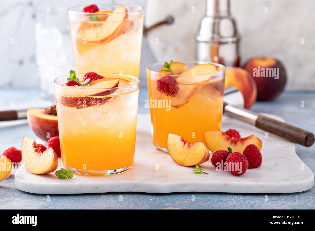 Refreshing summer cocktail with peach and raspberry Stock Photo - Alamy