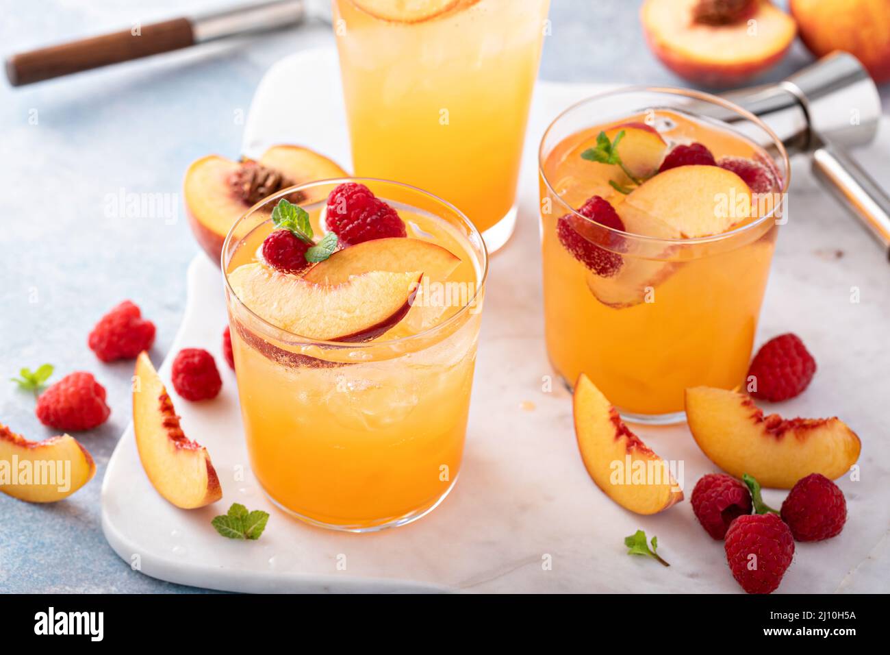 Refreshing summer cocktail with peach and raspberry Stock Photo - Alamy