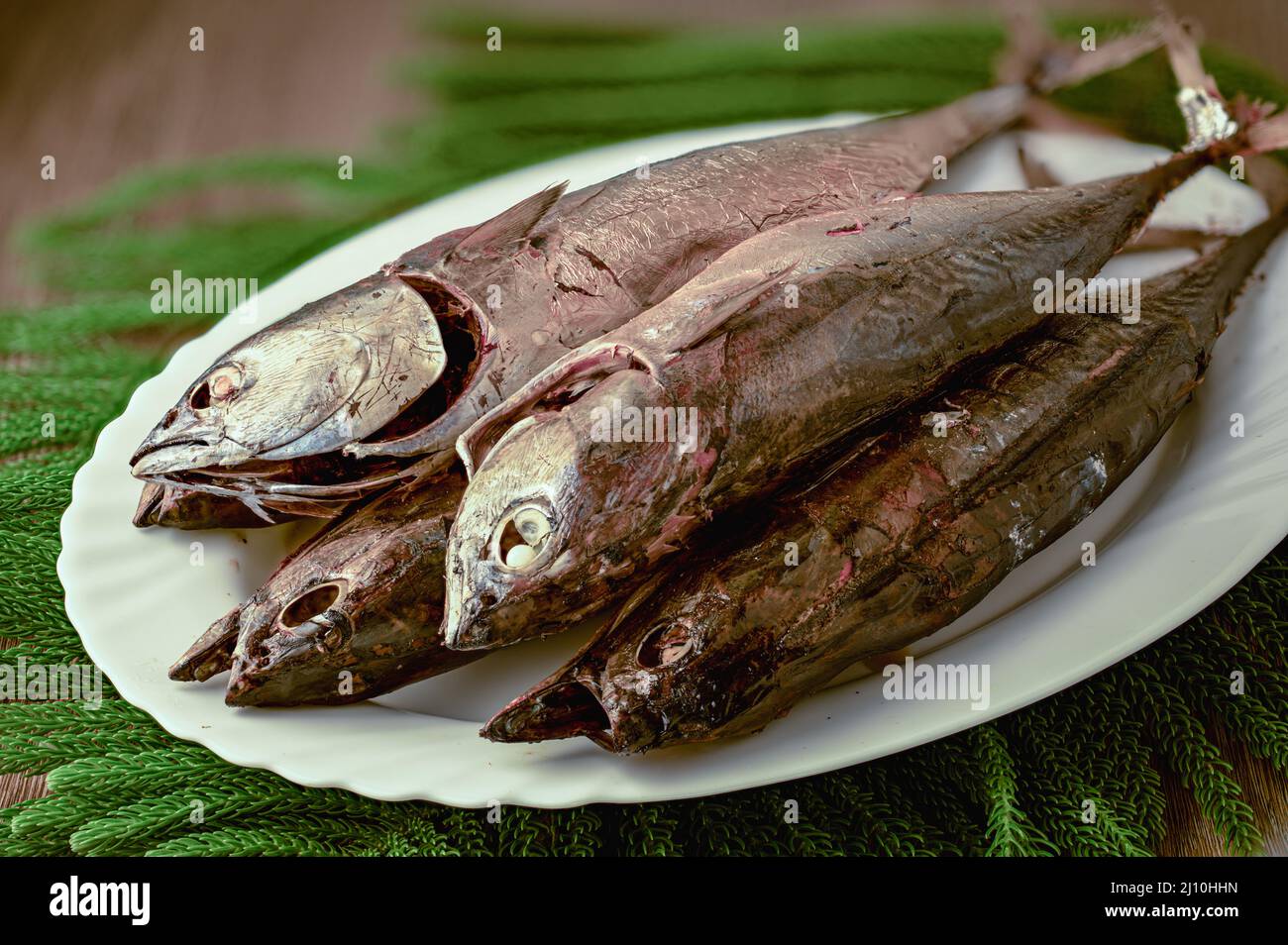The photo shows a plate with several smoked tuna. Fried fish on a fire ...