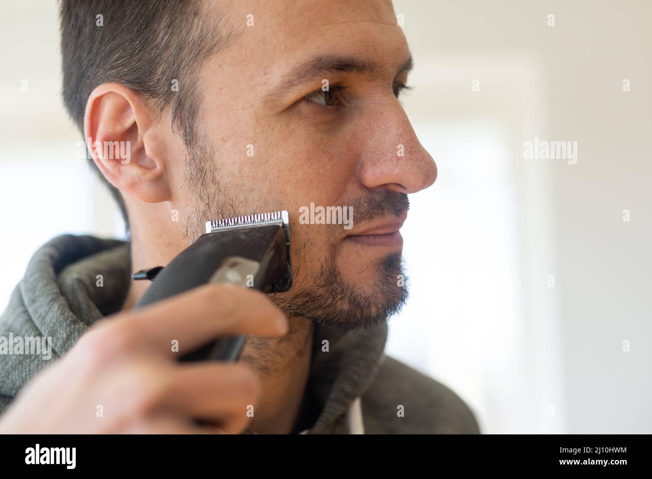 Happy guy using electric razor Stock Photo - Alamy