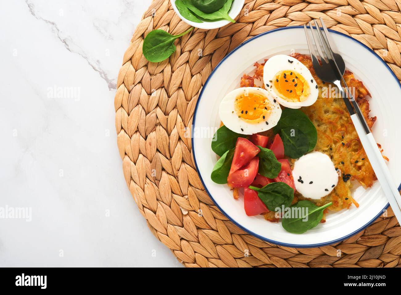 Breakfast. Potatoes latkes with sour cream, spinach salad, tomatoes and ...