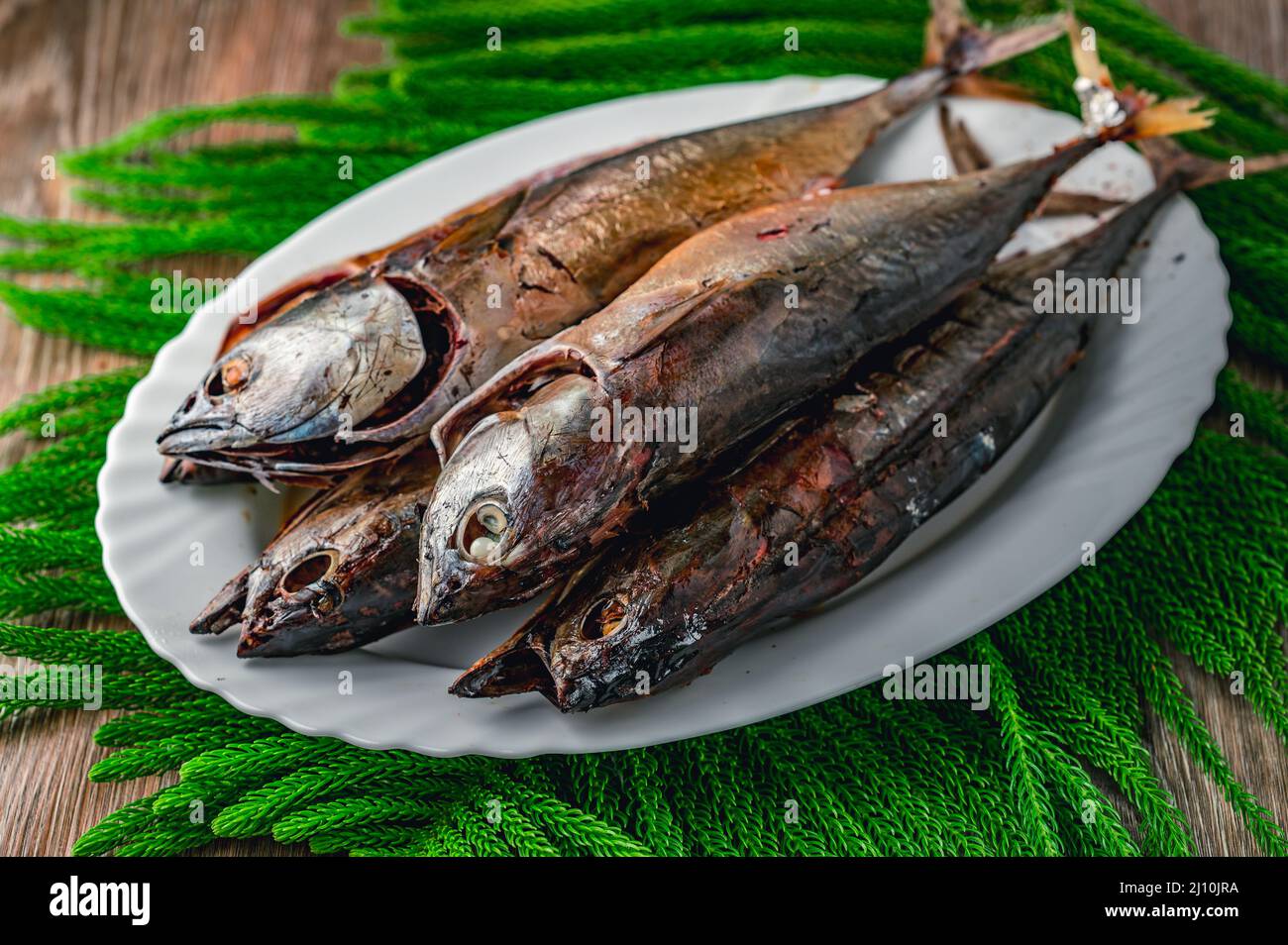 The photo shows a plate with several smoked tuna. Fried fish on a fire ...
