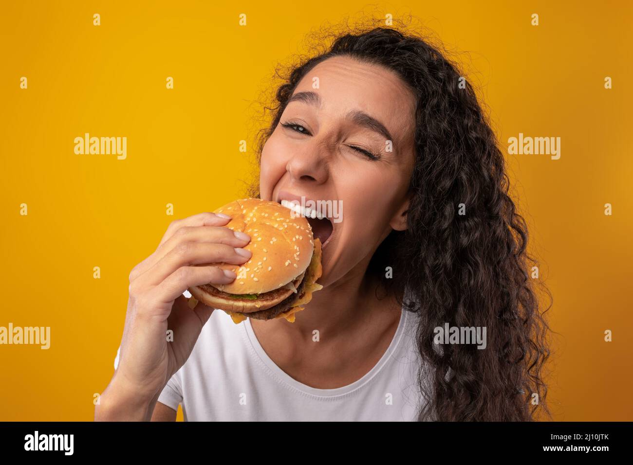 Hungry Latin Lady Holding Burger Biting Sandwich At Studio Stock Photo ...