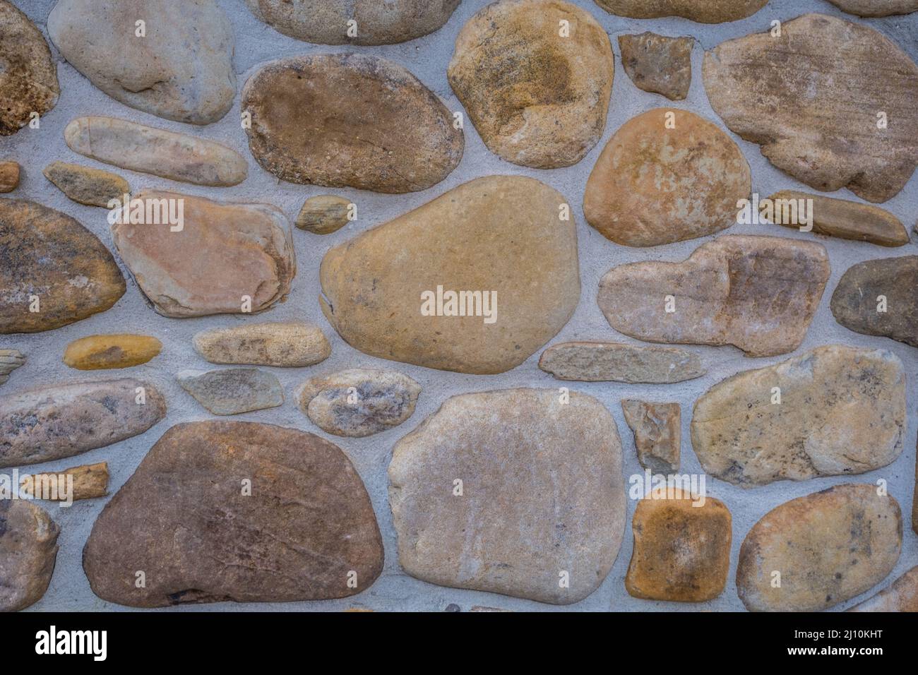 Various colorful river rocks made into a exterior wall on a building ...