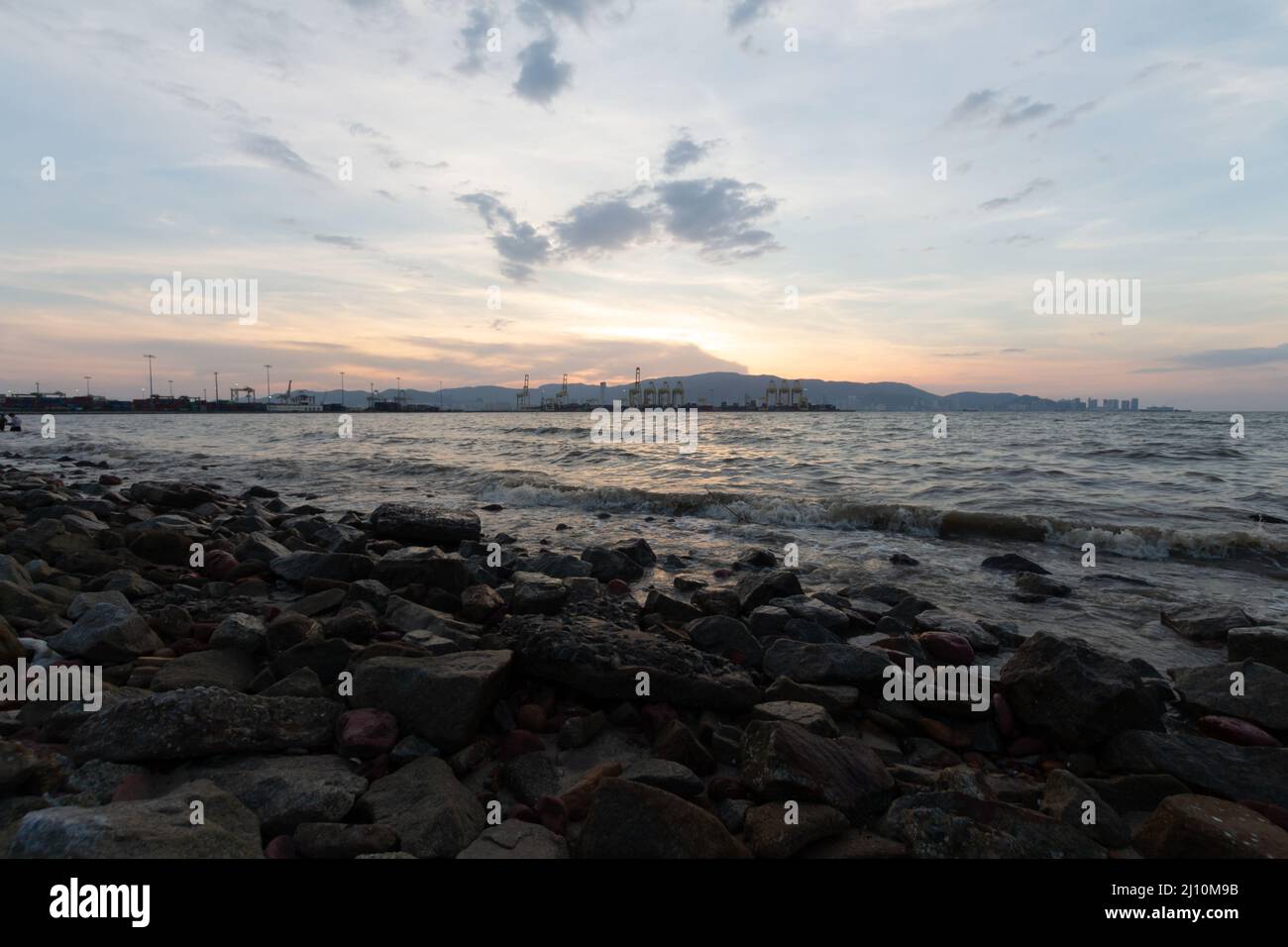 Rocky at the beach in sunset hour. Background is Penang Island Stock ...