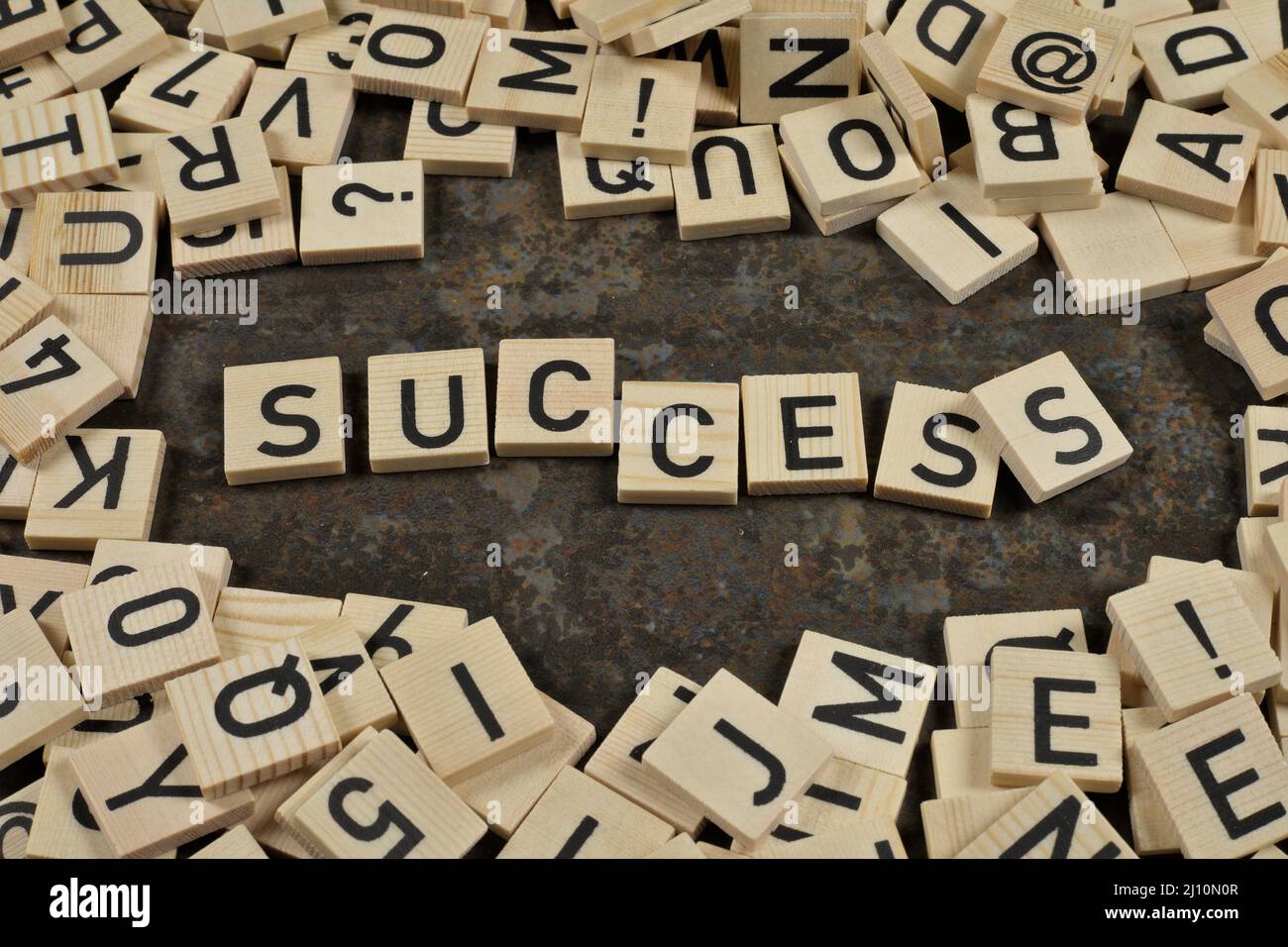 "success" phrase surrounded by letters on a brown ceramic background ...