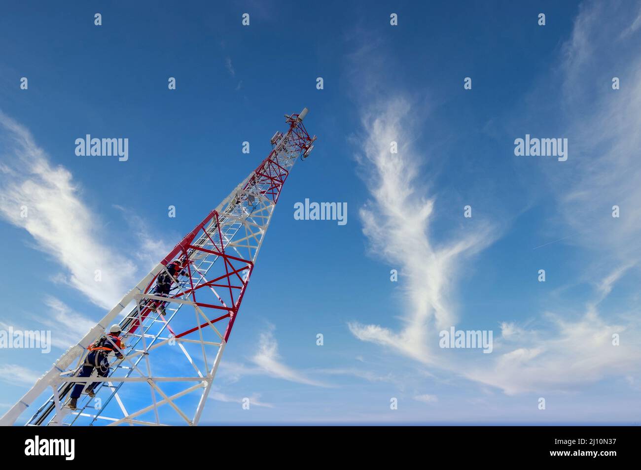 Low angle shot of two civil workers working on a telecommunication ...