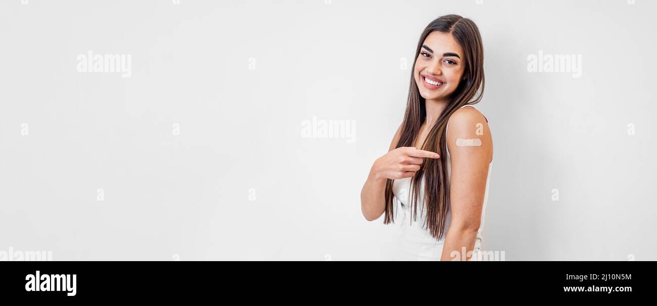 Picture of healthy young girl, pointing to her bad aid on her shoulder ...