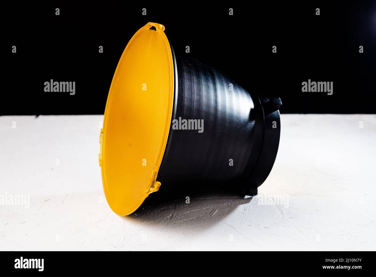 Standard reflector with a matte yellow diffuser on a black background ...