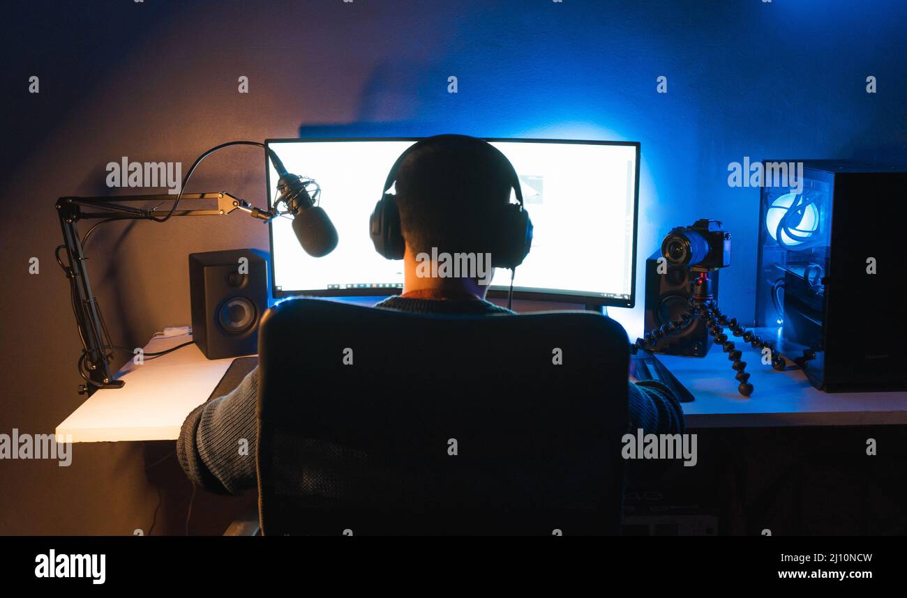Gamer with headphones playing in his dark room Stock Photo - Alamy