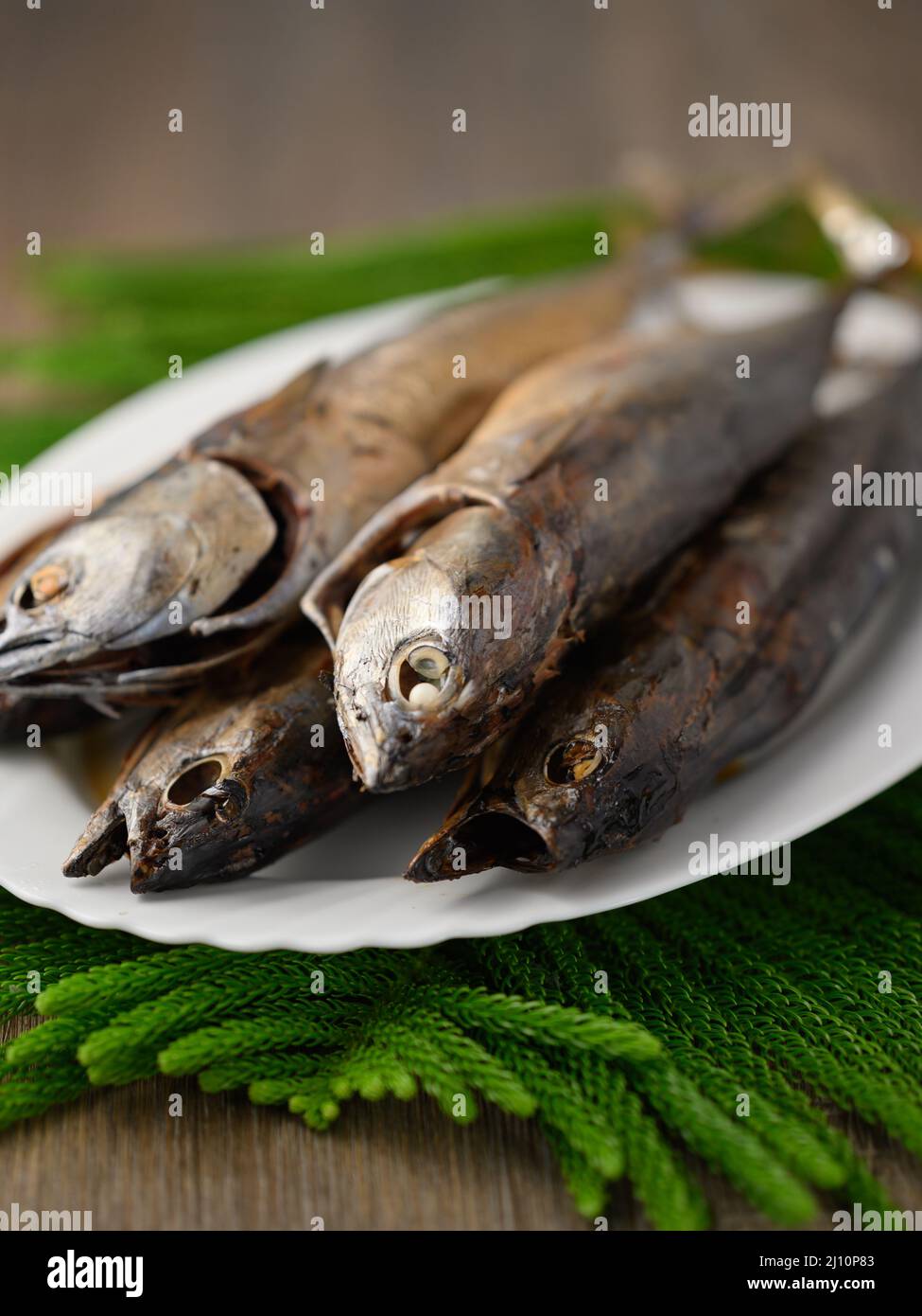 The photo shows a plate with several smoked tuna. Fried fish on a fire ...