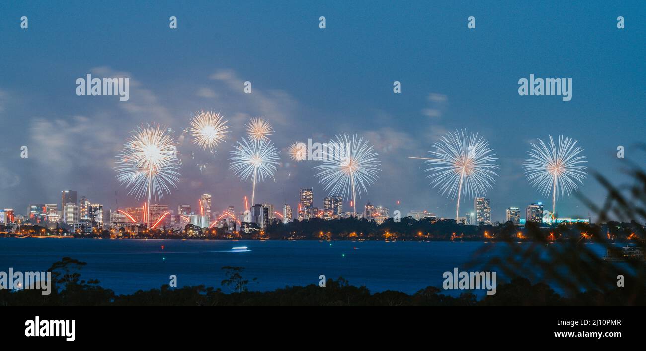 Scenic panorama with fireworks at the coast behind the body of water ...