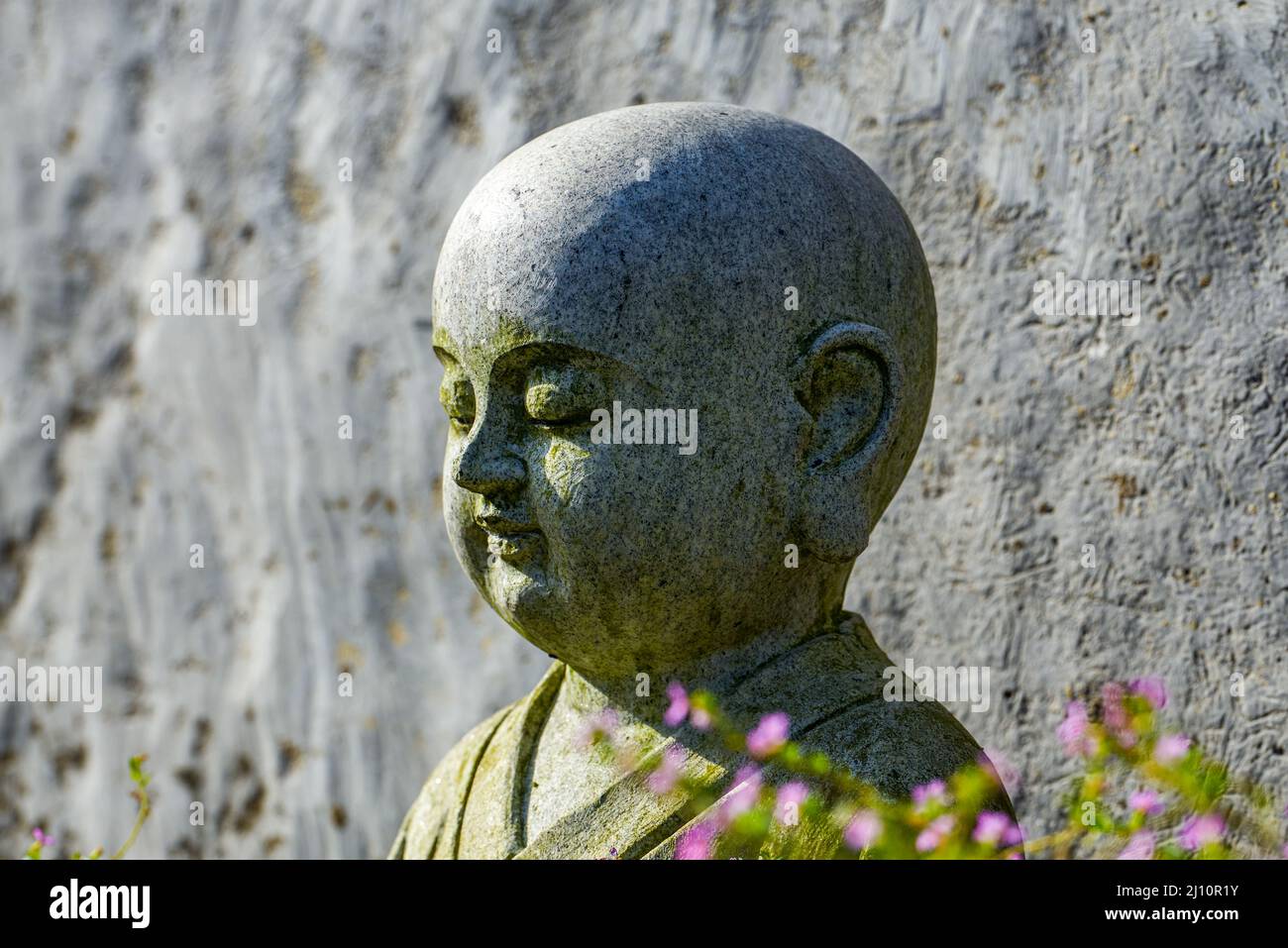 A stone sculpture of a child monk Stock Photo - Alamy