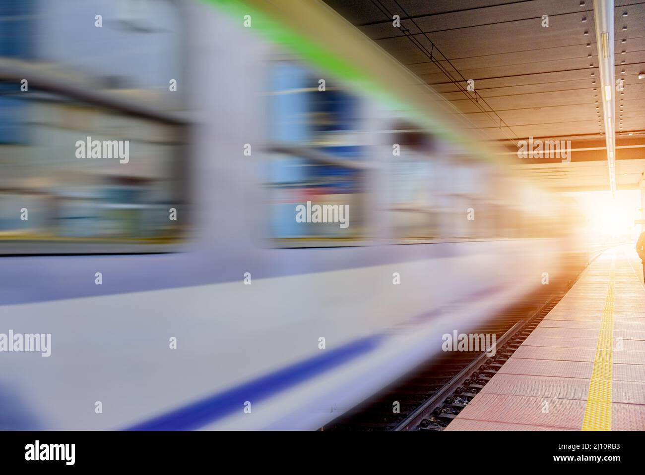Passenger train in motion on the station platform. Train blurred. Post ...