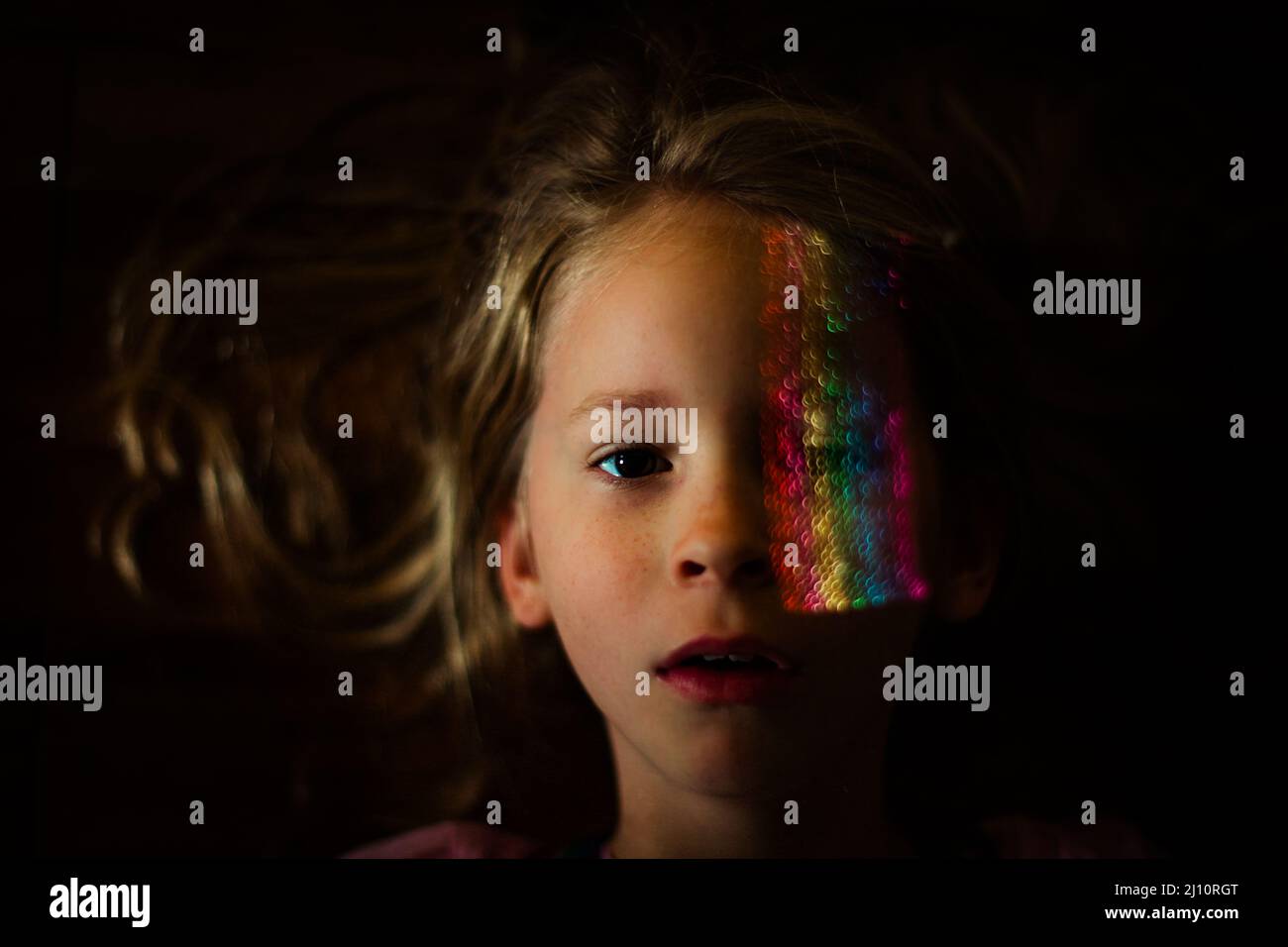 Brown eyed child with rainbow light over her eye Stock Photo - Alamy