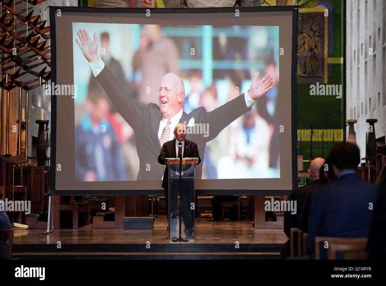 Gary Newbon speaks in front of an image of John Sillett (left), Jimmy ...