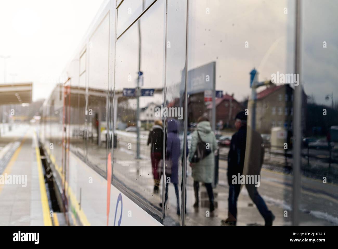 People rush to the train. Reflection of people in the window of a ...