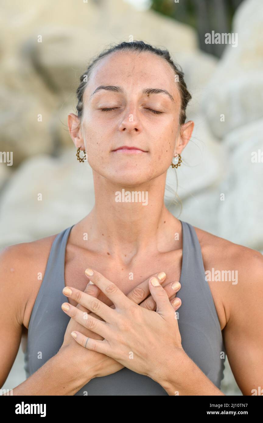 Woman meditating hand on heart hi-res stock photography and images - Alamy