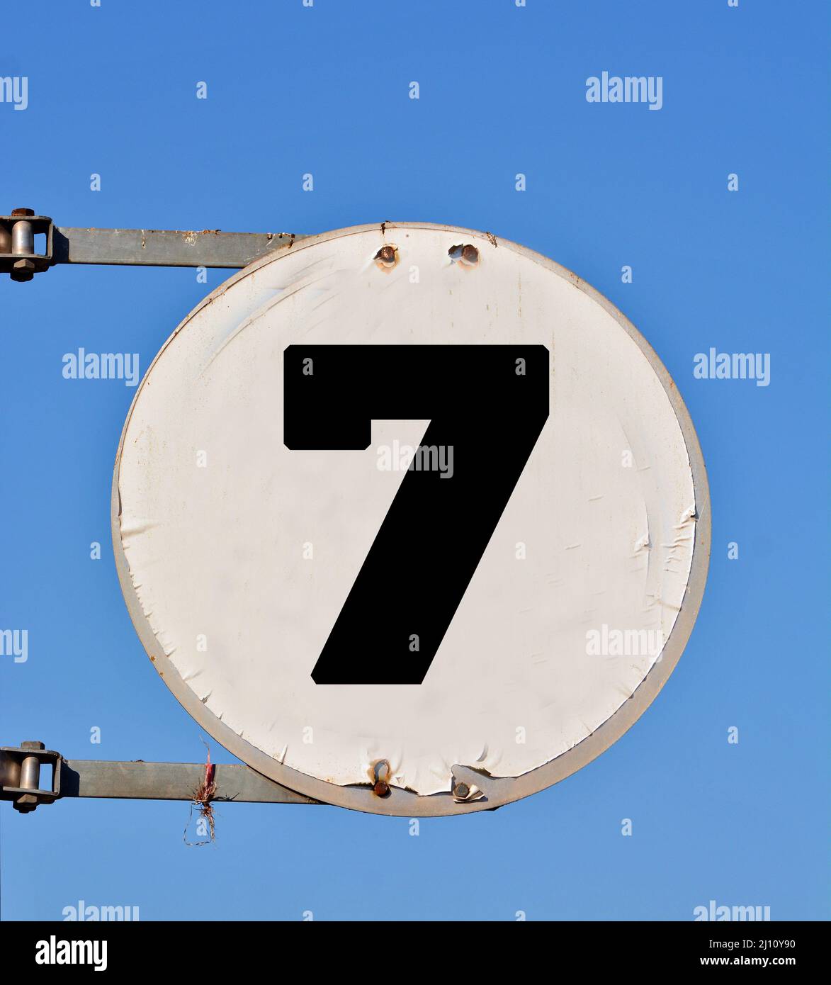 A round-shaped street banner with the number 7 on it in the background ...